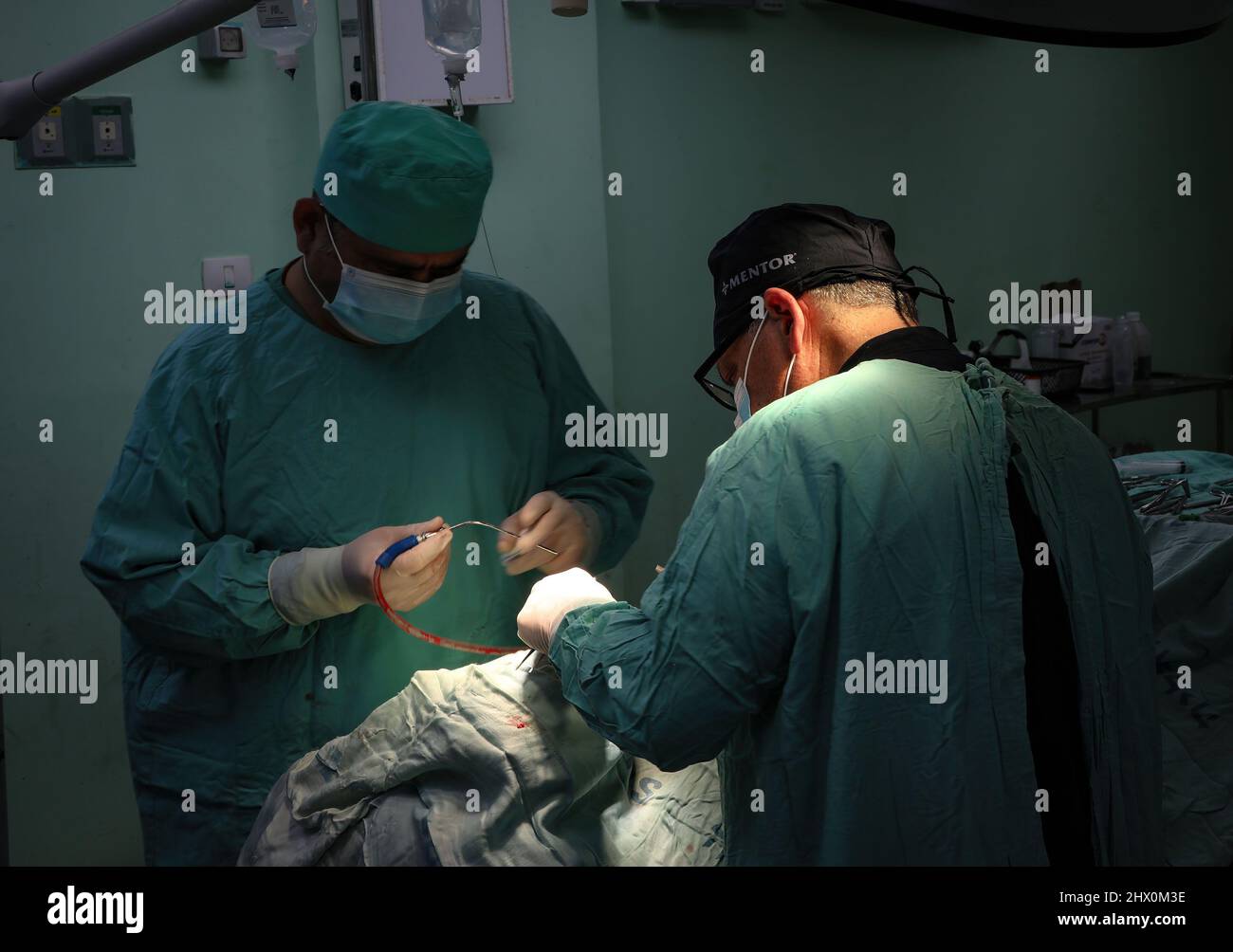 Palestinian doctors in the Gaza Strip perform a plastic surgery on a ...