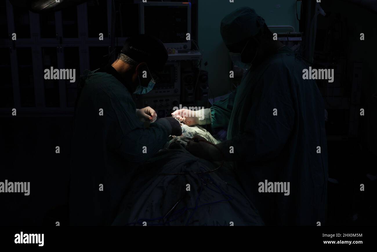 Palestinian doctors in the Gaza Strip perform a plastic surgery on a ...