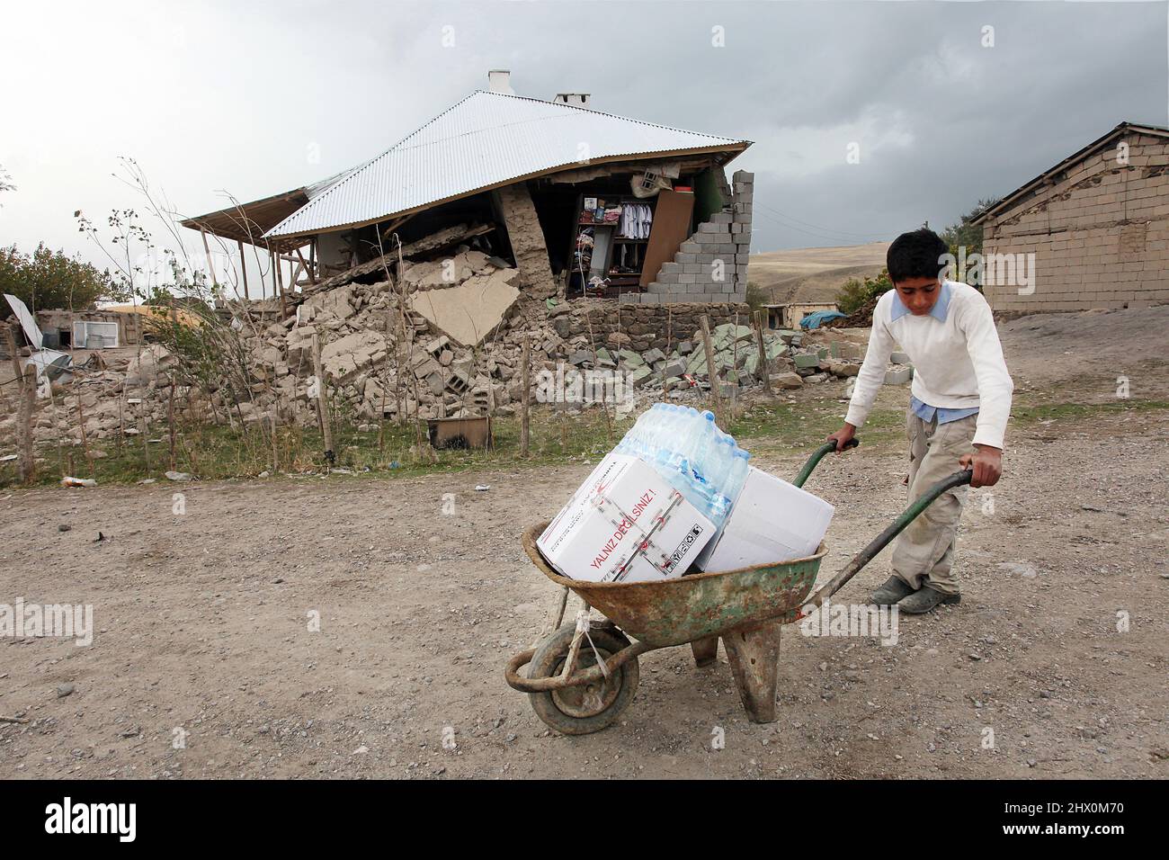 VAN, TURKEY - OCTOBER 25: Earthquake victim man carrying stuff in front ...