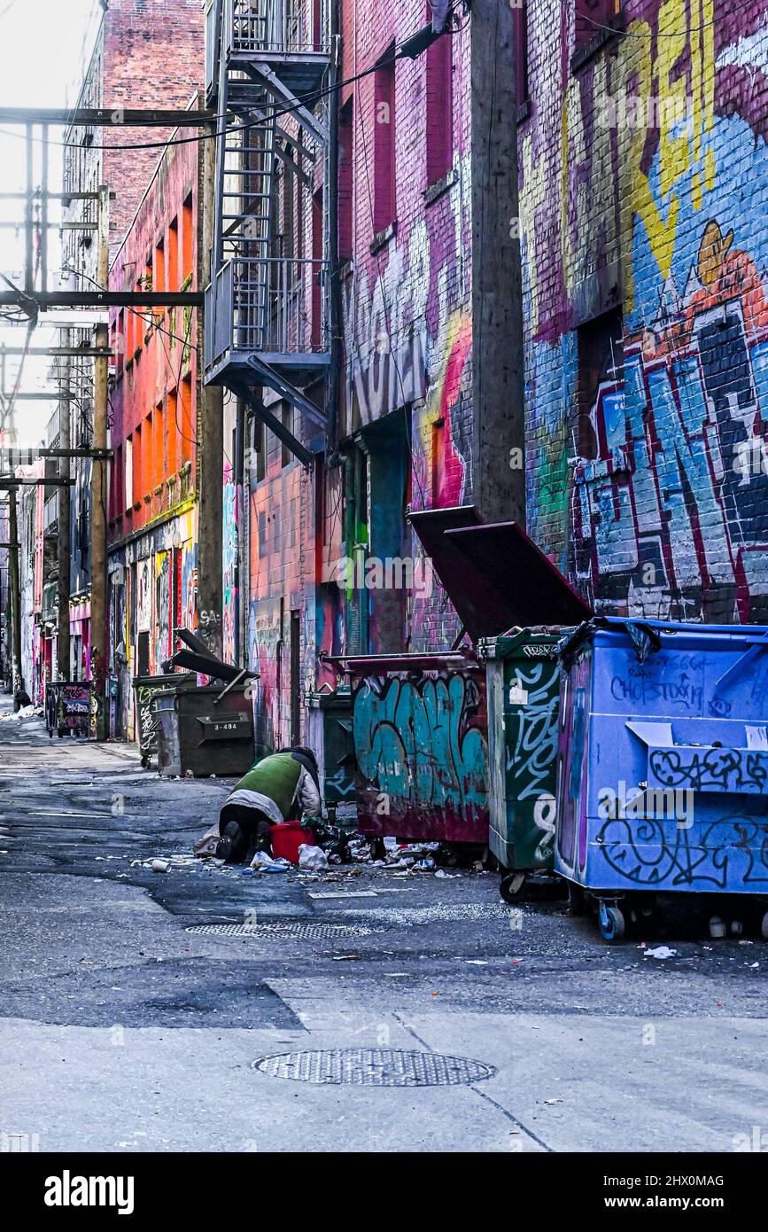 Homeless person scavenging in Downtown Eastside alley, Vancouver ...