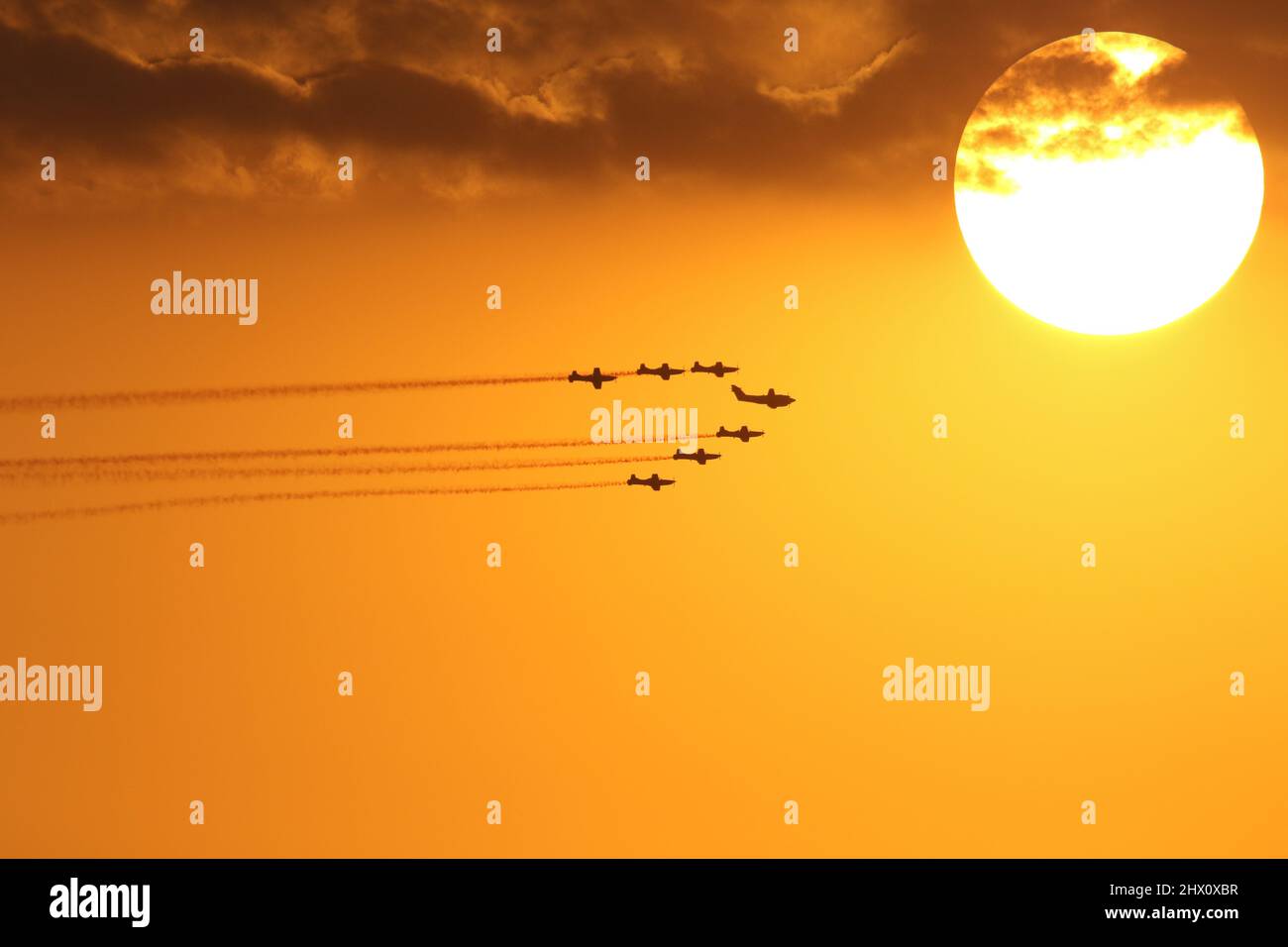 Aircraft formation travelling past a large bright sun Stock Photo - Alamy