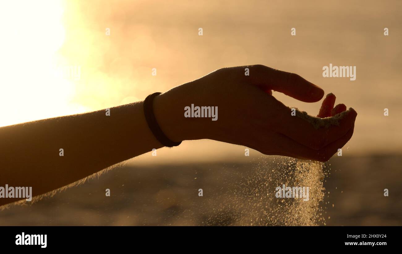 Young woman playing with sand on a beach at sunset - slow motion Stock ...