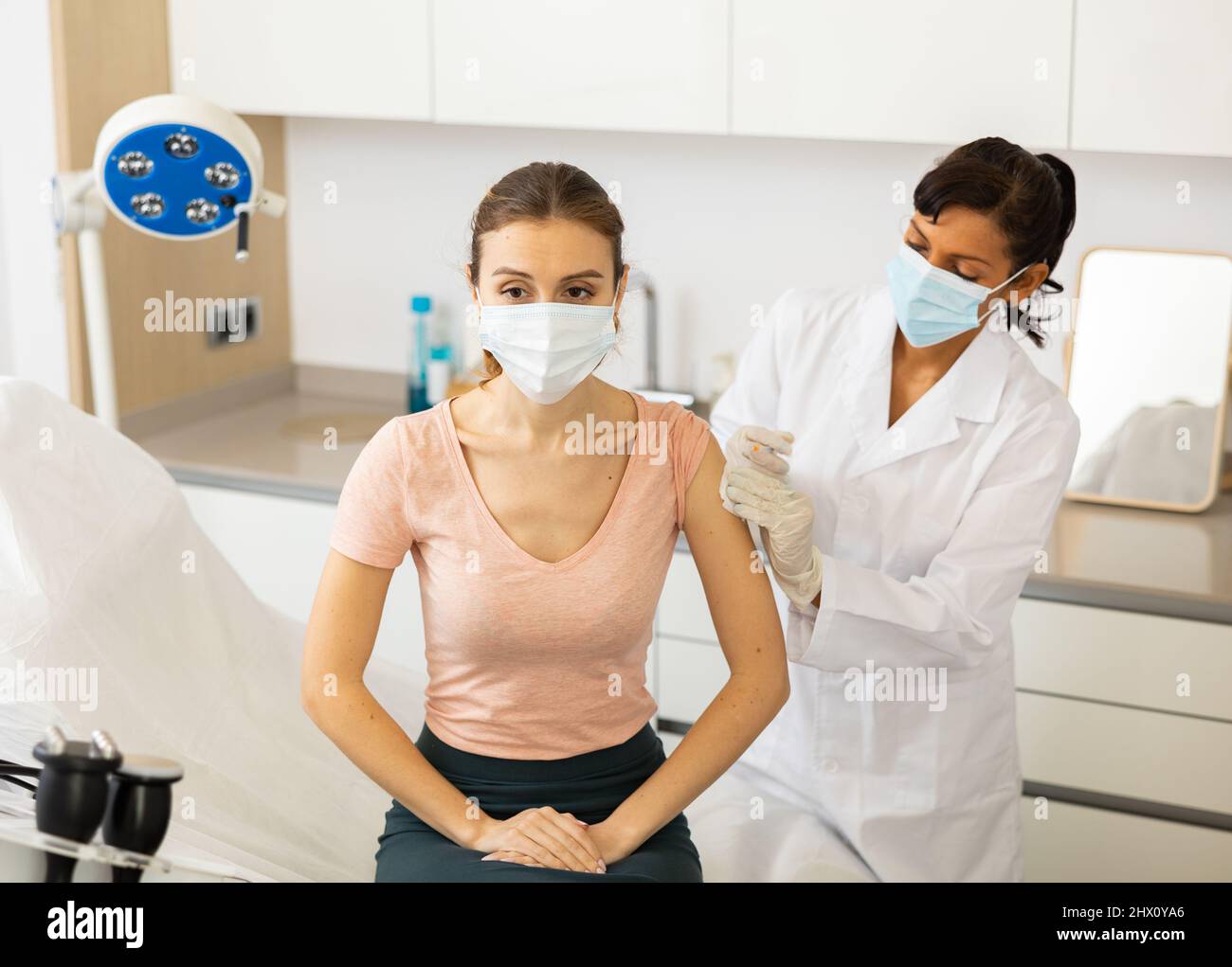 Confident female doctor making injection to woman Stock Photo - Alamy