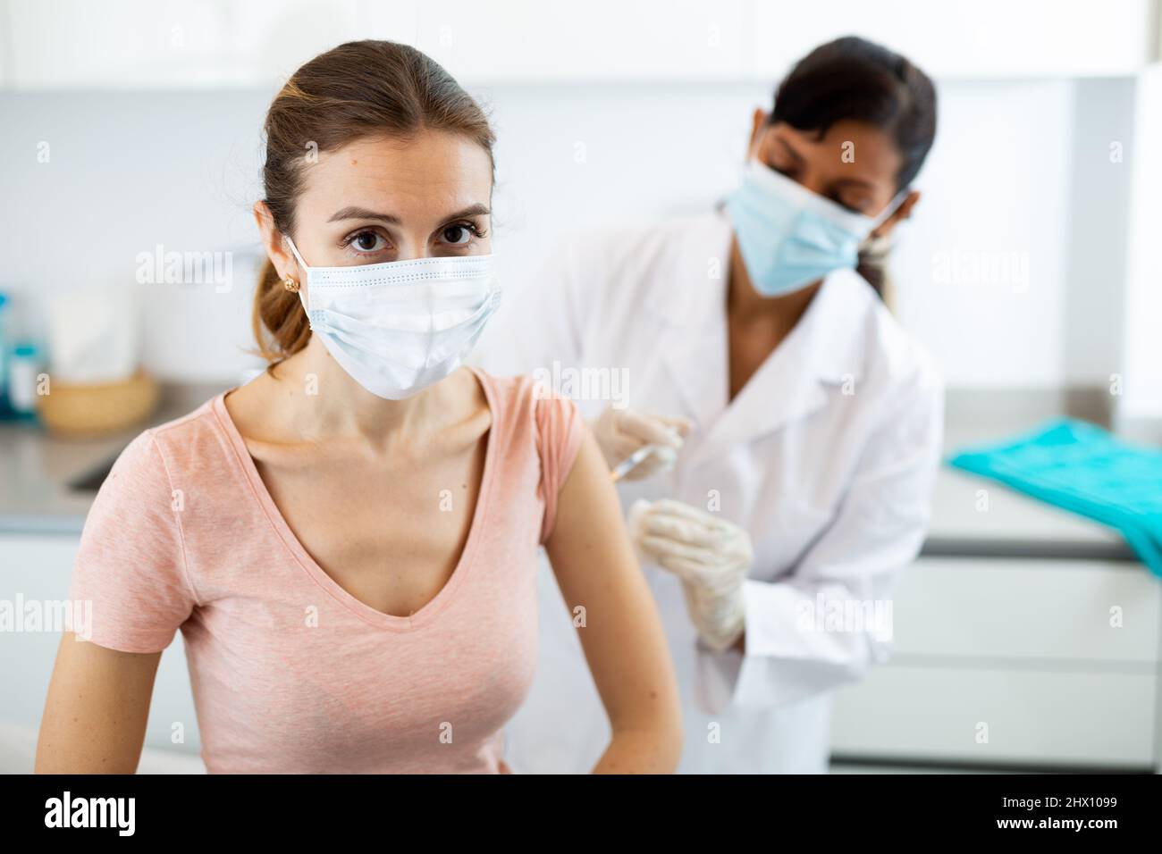 Confident female doctor making injection to woman Stock Photo - Alamy