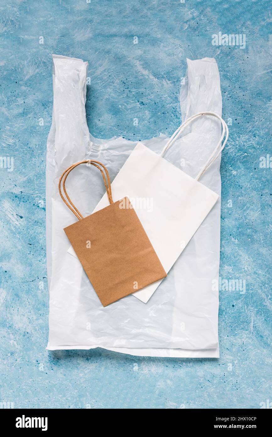 single use plastic bag next to paper ones, plastic pollution and ...
