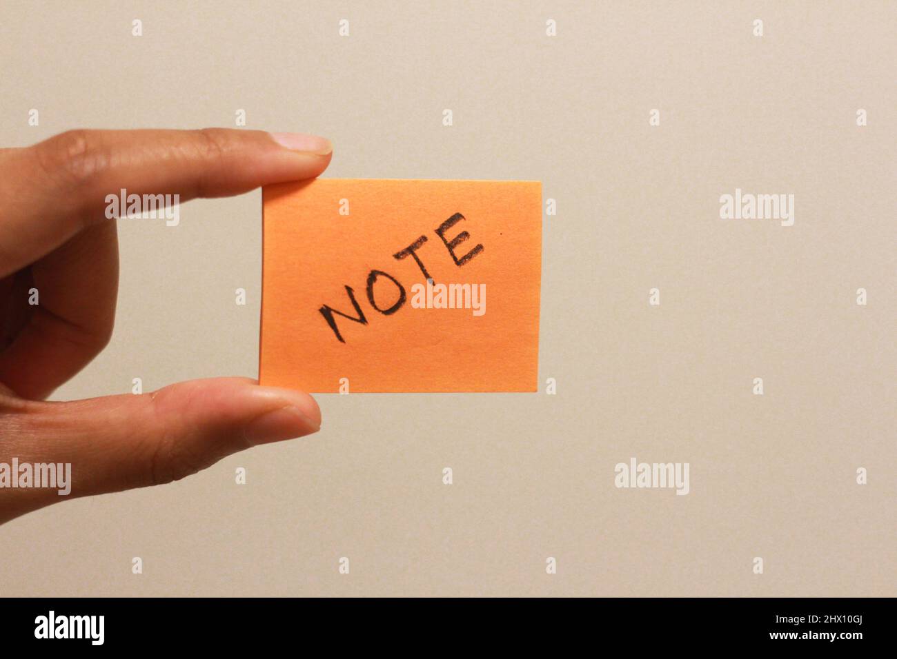 hand holding sticky note in white background Stock Photo - Alamy