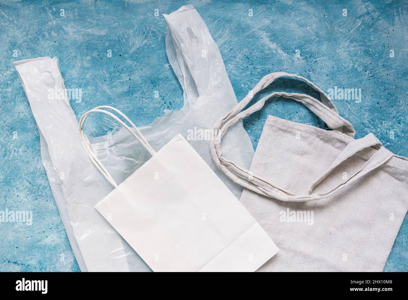 single use plastic bag next to paper and reusable canvas ones, plastic ...