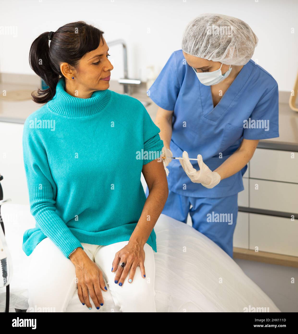 Adult woman getting injection at doctors office Stock Photo - Alamy