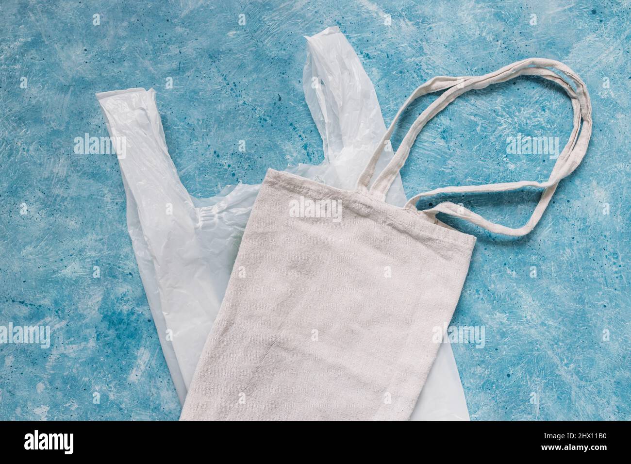 single use plastic bag next to reusable canvas one, plastic pollution ...