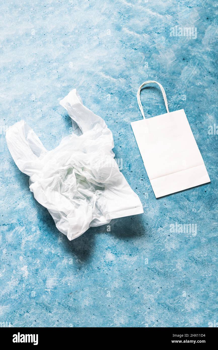 single use plastic bag next to paper one, plastic pollution and ...