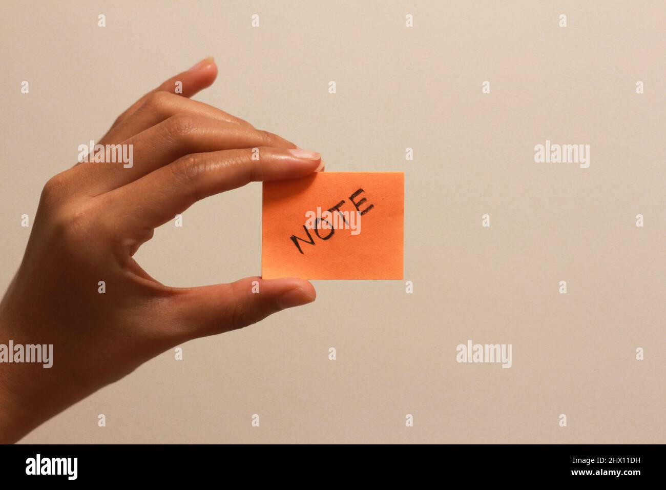 hand holding sticky note in white background Stock Photo - Alamy