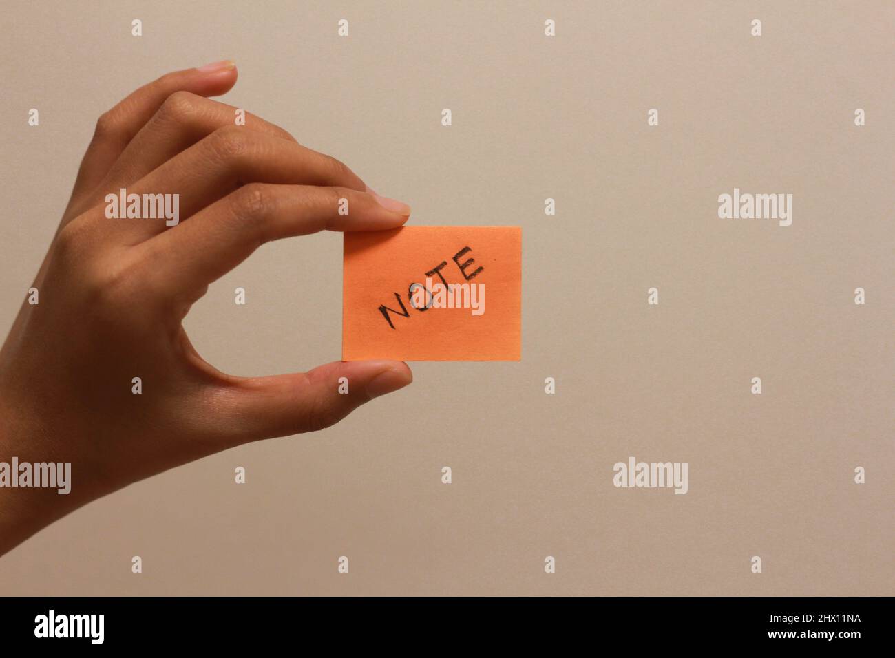 hand holding sticky note in white background Stock Photo - Alamy