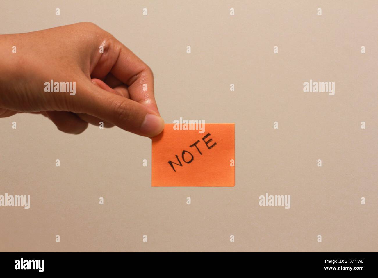 hand holding sticky note in white background Stock Photo - Alamy