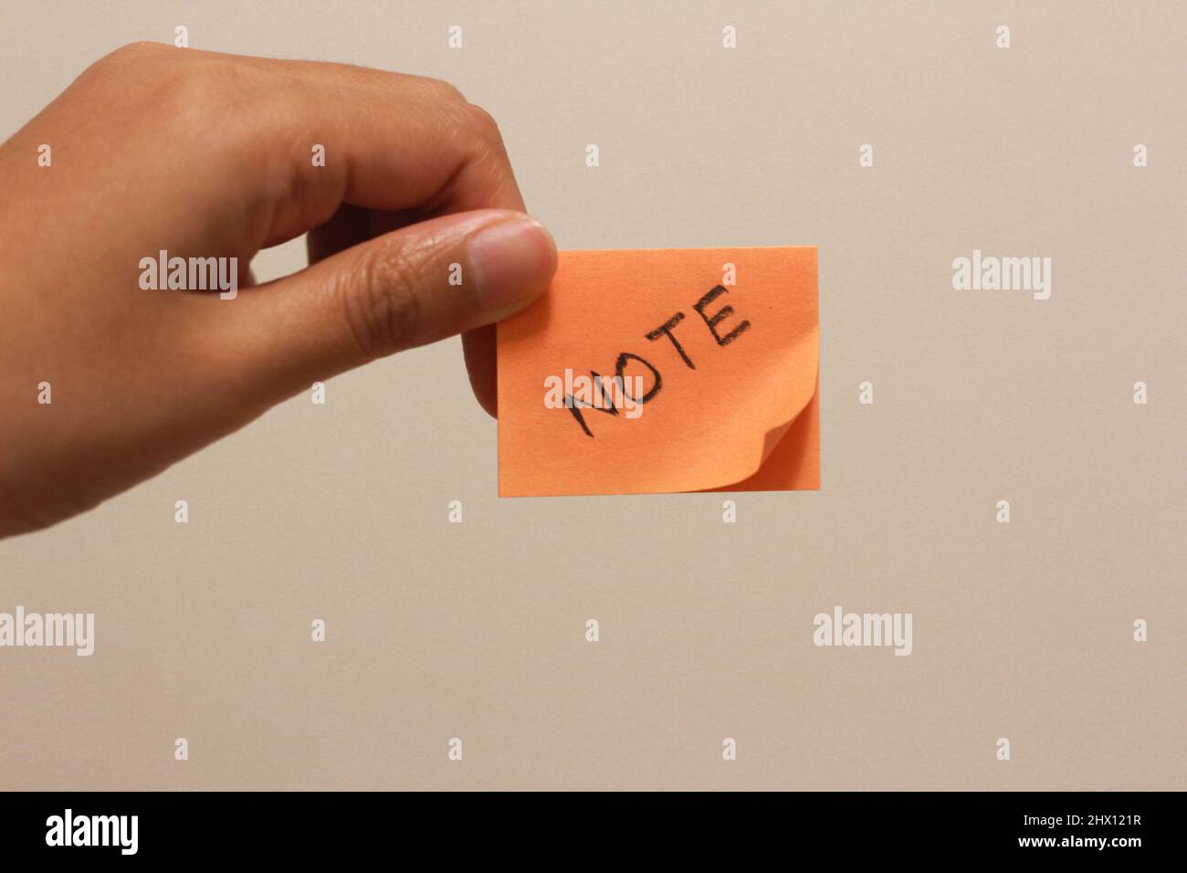hand holding sticky note in white background Stock Photo - Alamy