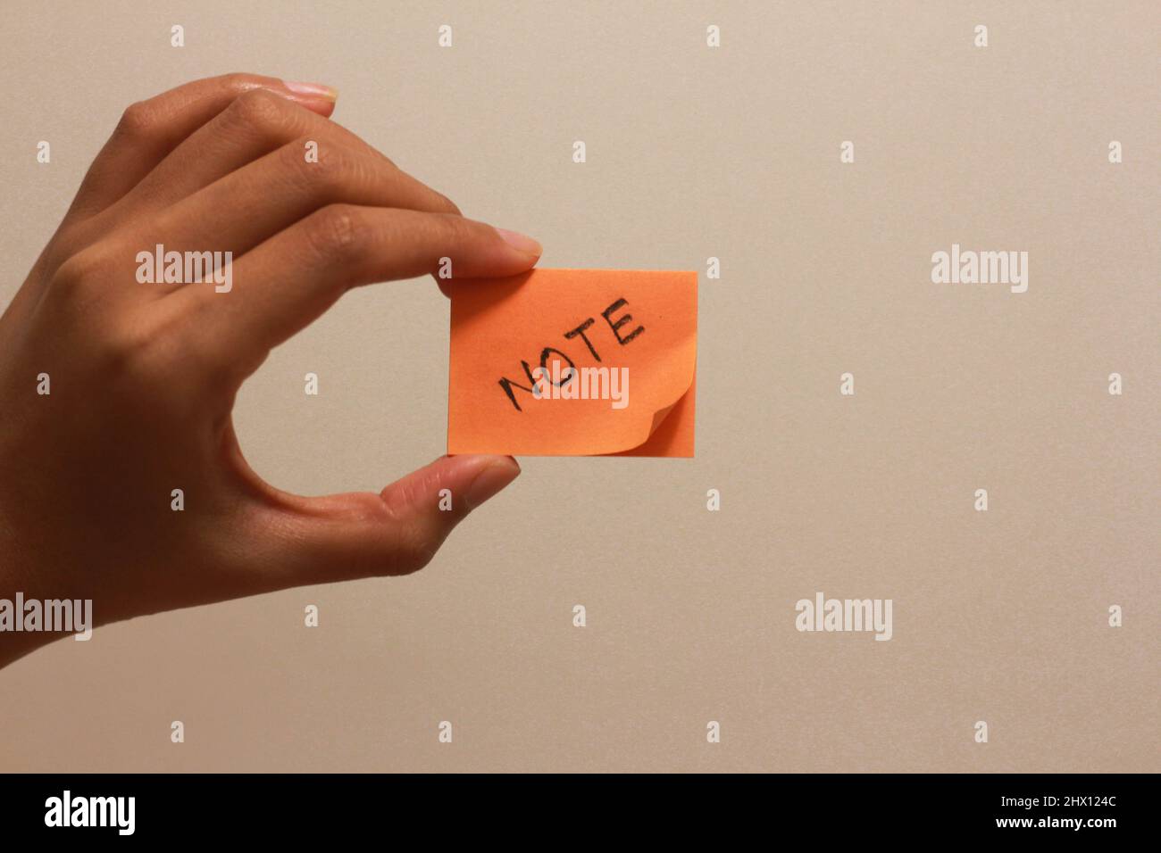hand holding sticky note in white background Stock Photo - Alamy
