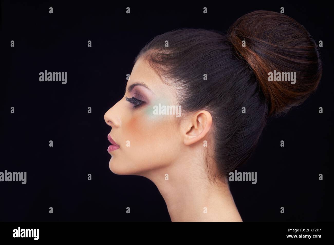 Her bold side. Profile of a beautiful young woman against a black ...