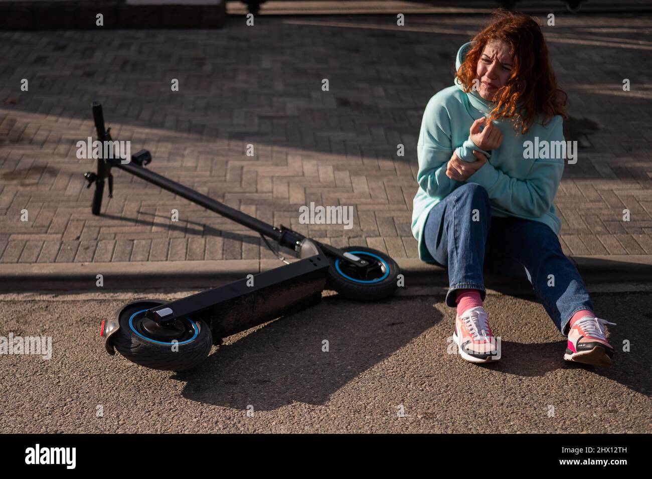 A Caucasian woman fell from an electric scooter and injured her arm ...