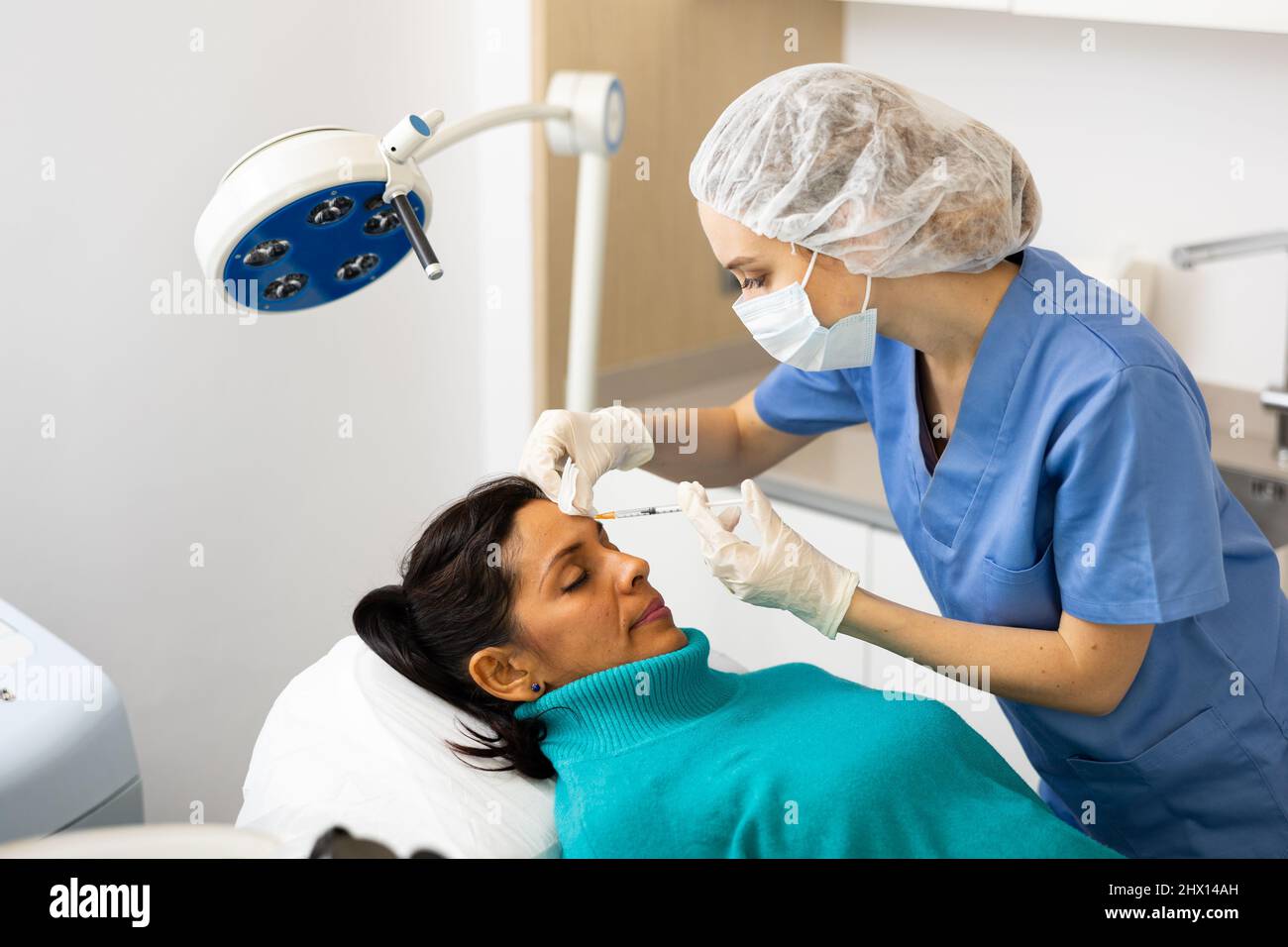 Woman patient receiving forehead injection at clinic Stock Photo - Alamy