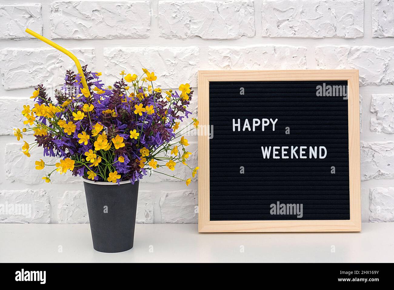 Happy weekend words on black letter board and bouquet of colored ...