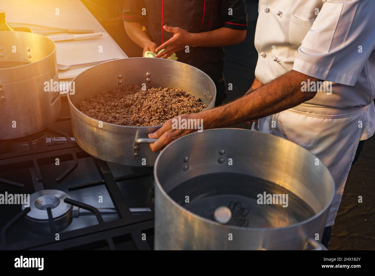 Professional chef giving classes to his student who serves as an ...
