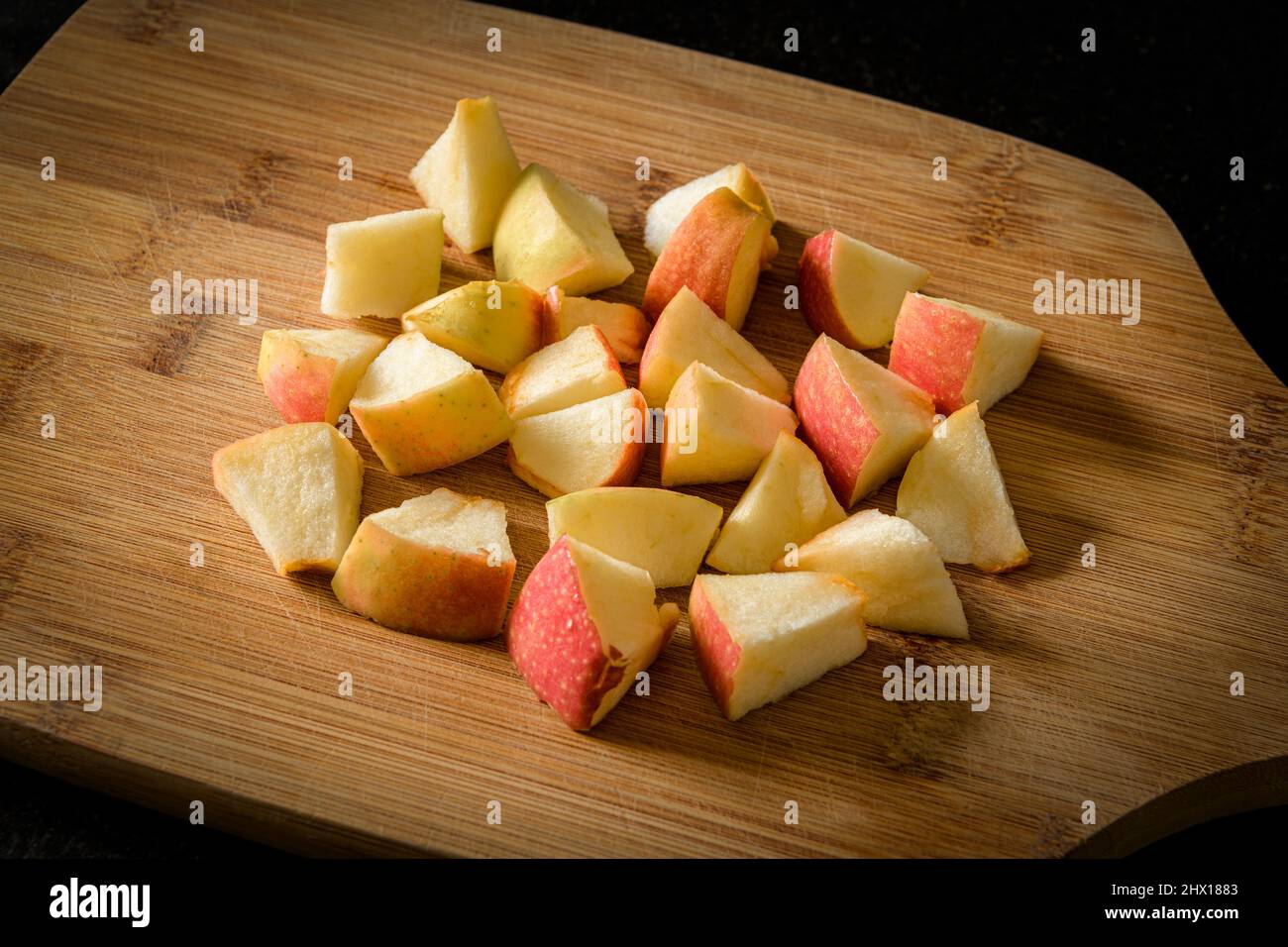 A pile of diced red apple. Pieces of apple sitting on the wooden ...