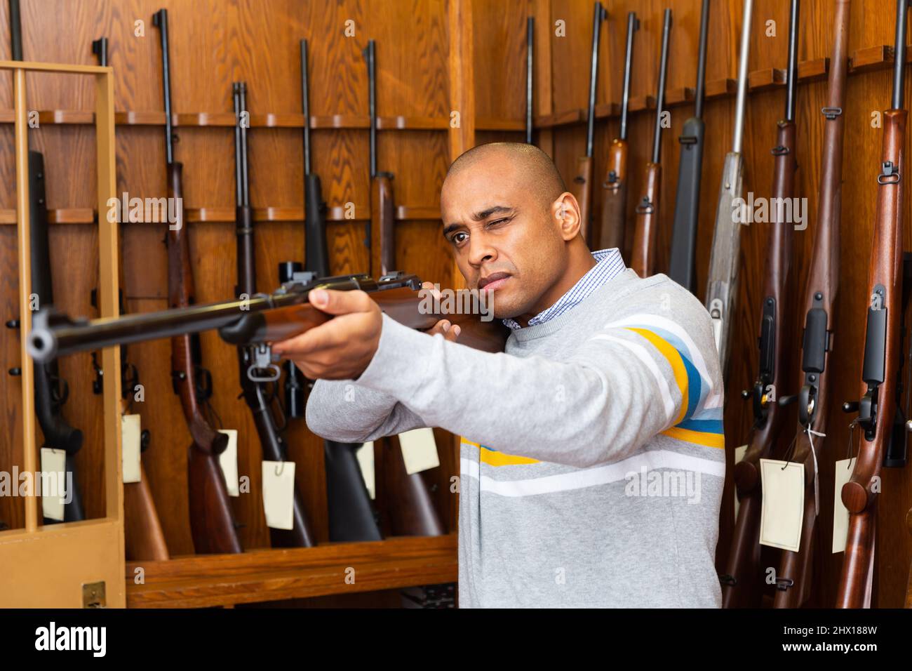 Portrait of confident man in gun shop showing rifle Stock Photo - Alamy