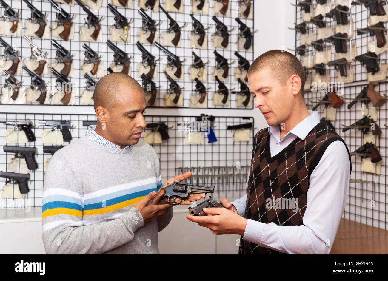 Two men choosing sporting and hunting revolvers in gunsmith shop Stock ...
