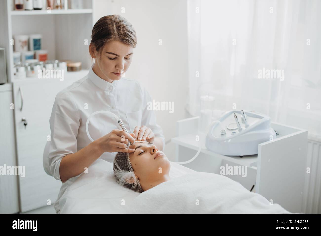 Cosmetologist making the Microdermabrasion procedure of the patient's ...