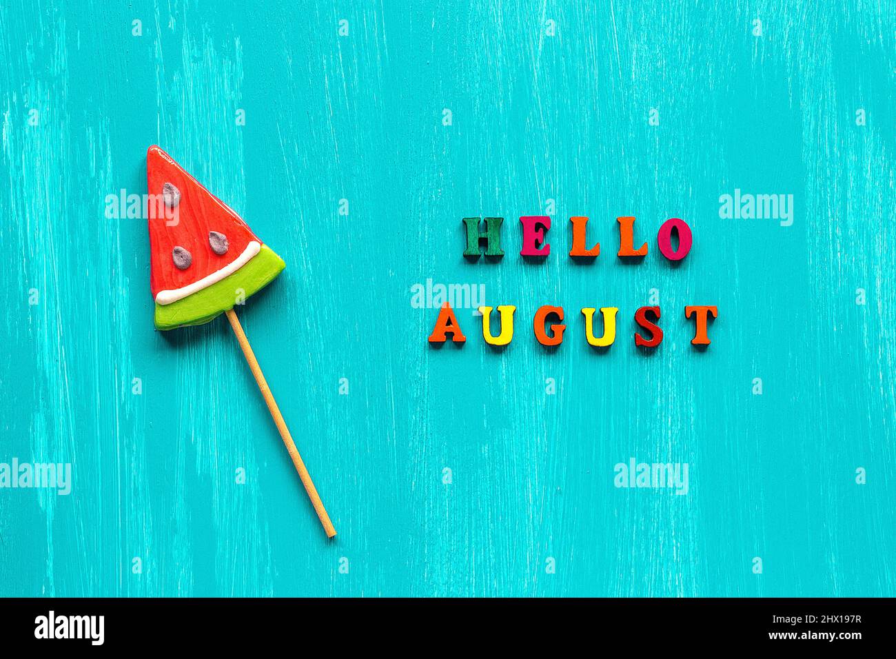 Hello August text from colorful letters and watermelon lollipop on ...