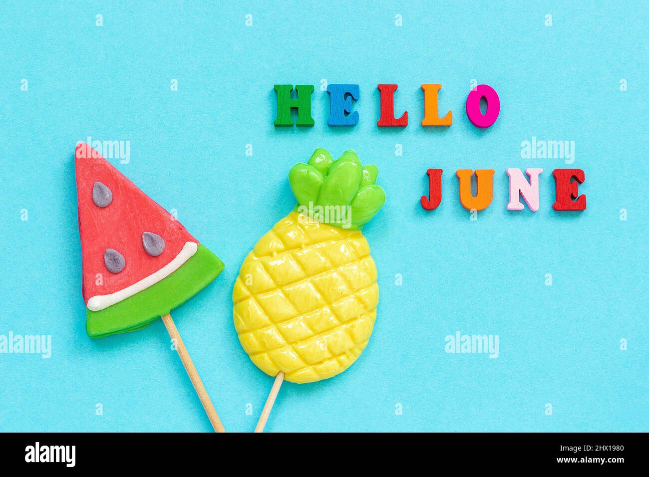 Hello June colorful text, pineapple and watermelon lollipops on stick ...