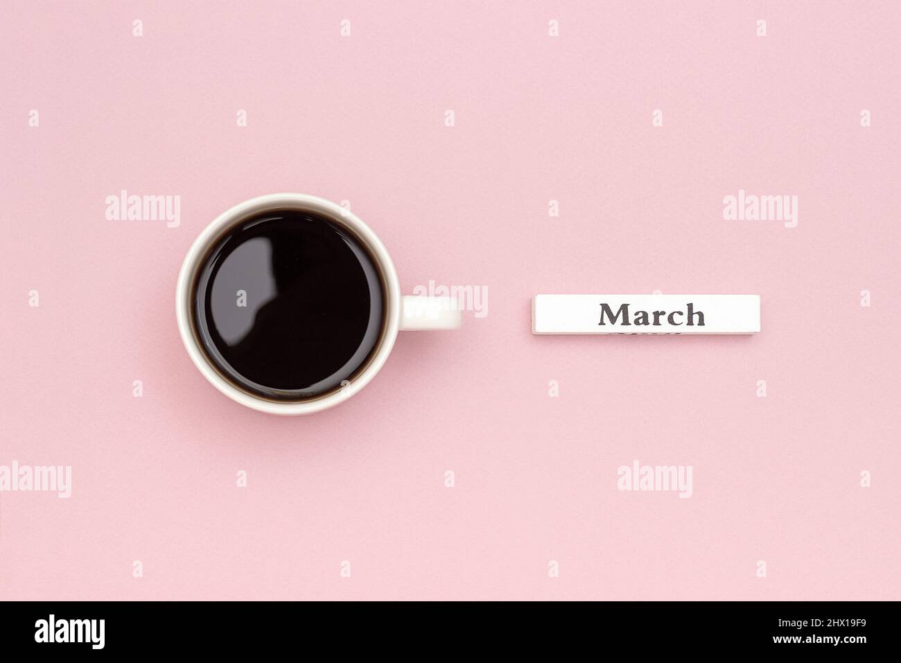 Wooden calendar spring month March and Cup of black coffee on pastel ...