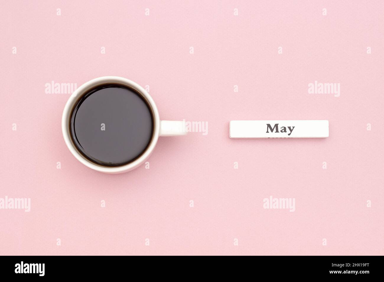 Wooden calendar spring month May and Cup of black coffee on pastel pink ...