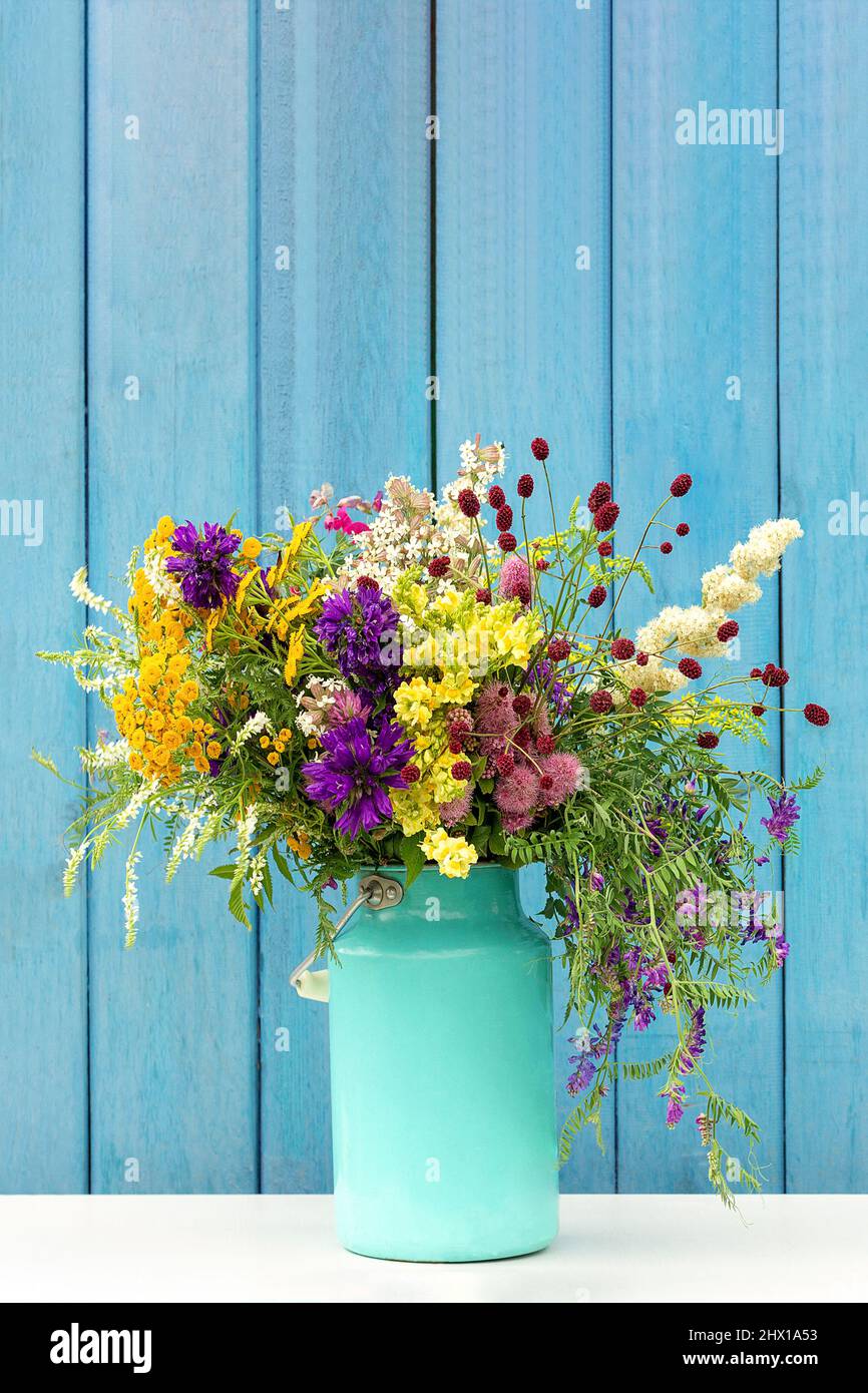 Bright colorful bouquet of wild flowers in starm tin can vase on ...