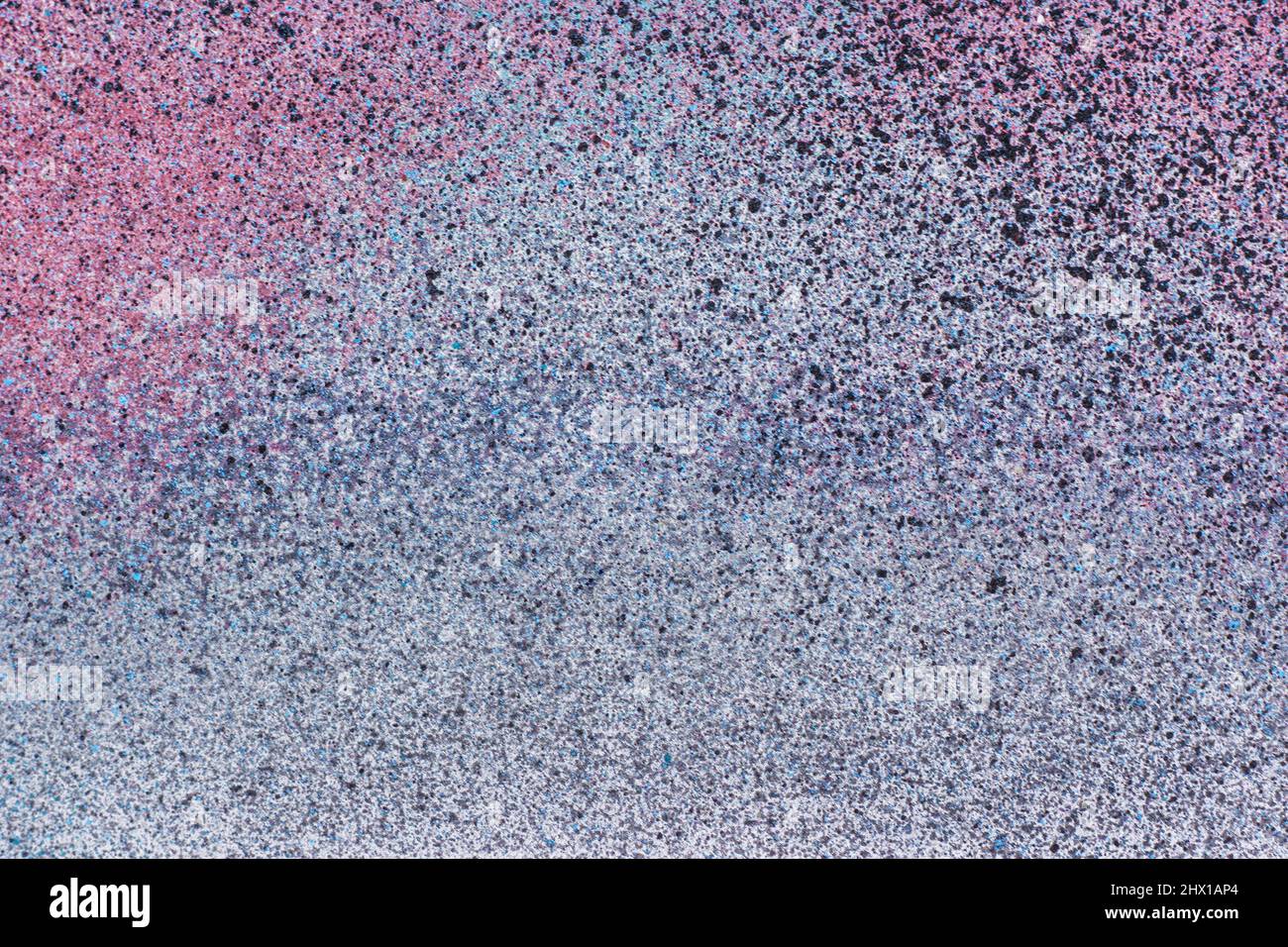 spray of colored aerosol paint on a grey metallic surface. abstract ...