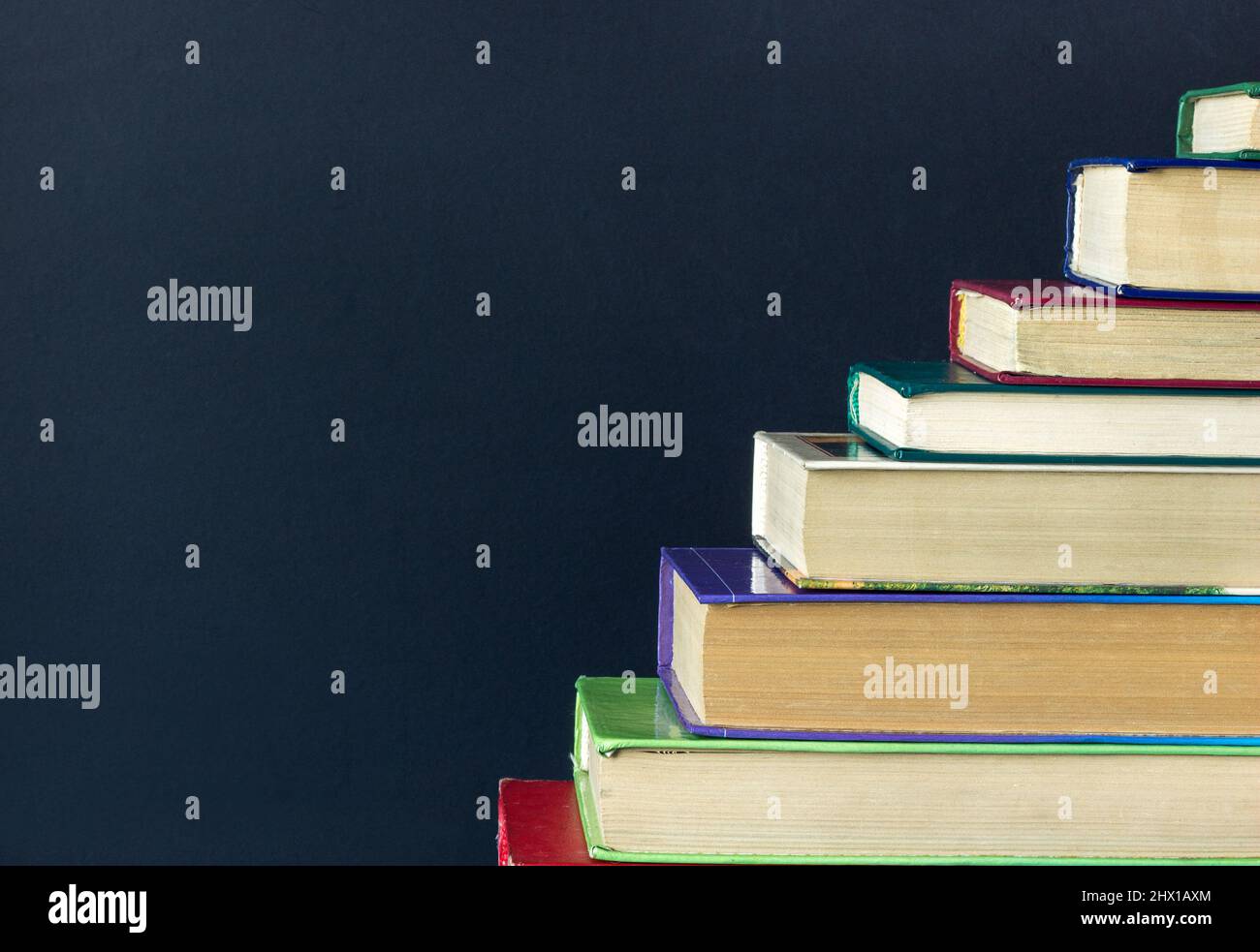 Stack steps stairs of old books on background black chalkboard, copy ...