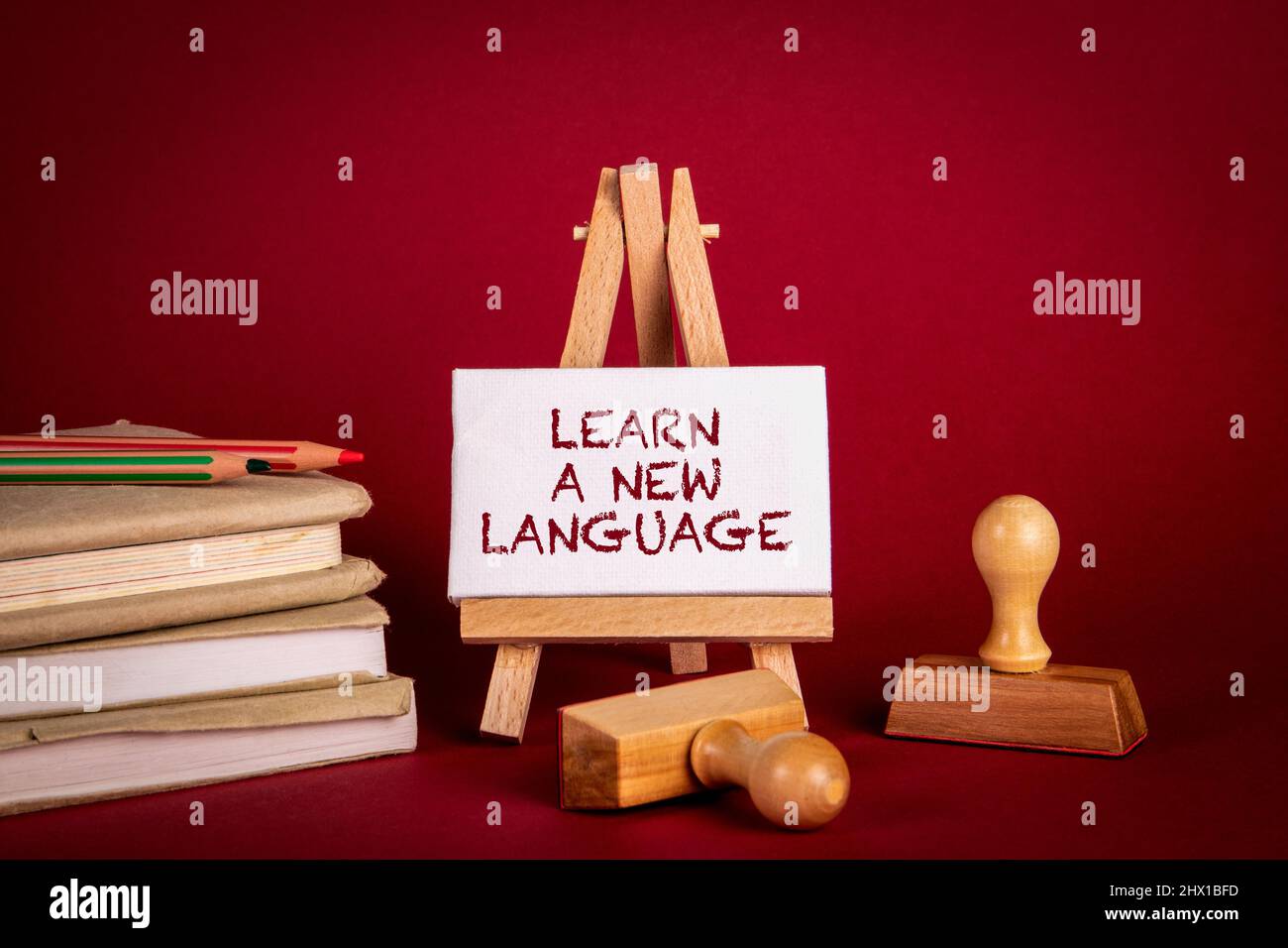 Learn a New Language. Stack of books and stamps on a red background ...