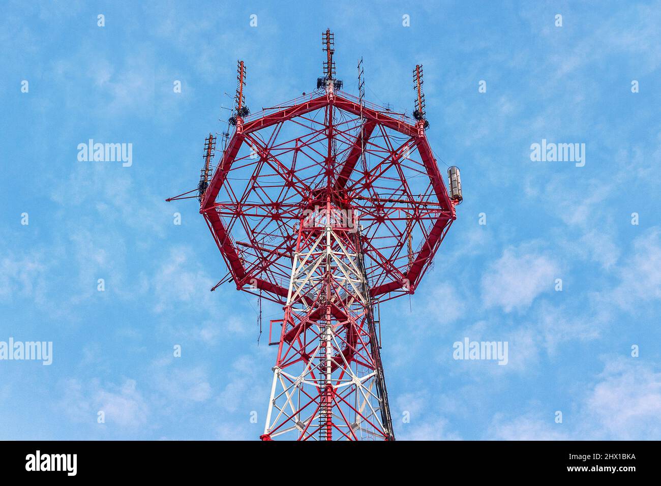Telecommunication tower with antennas on a background of blue sky with ...