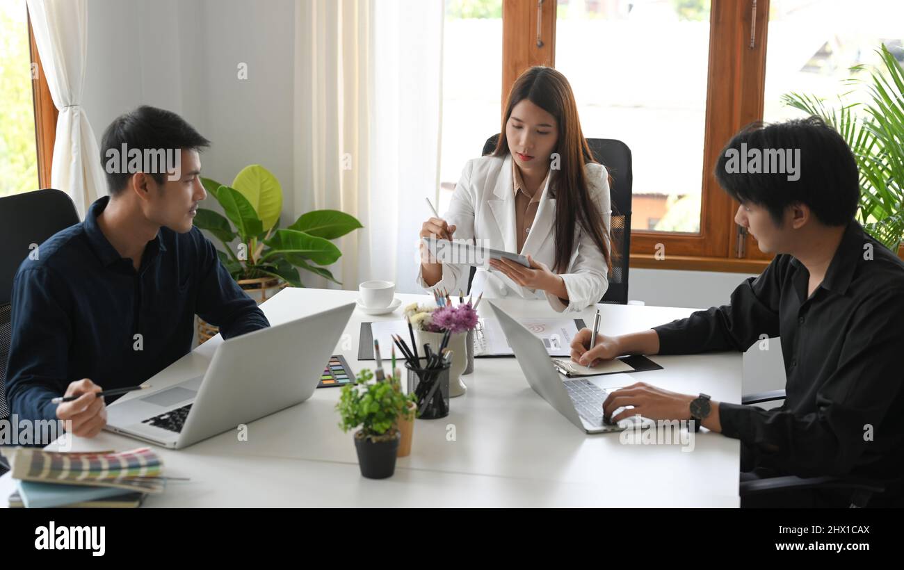 Successful asian young female entrepreneur having a meeting with ...