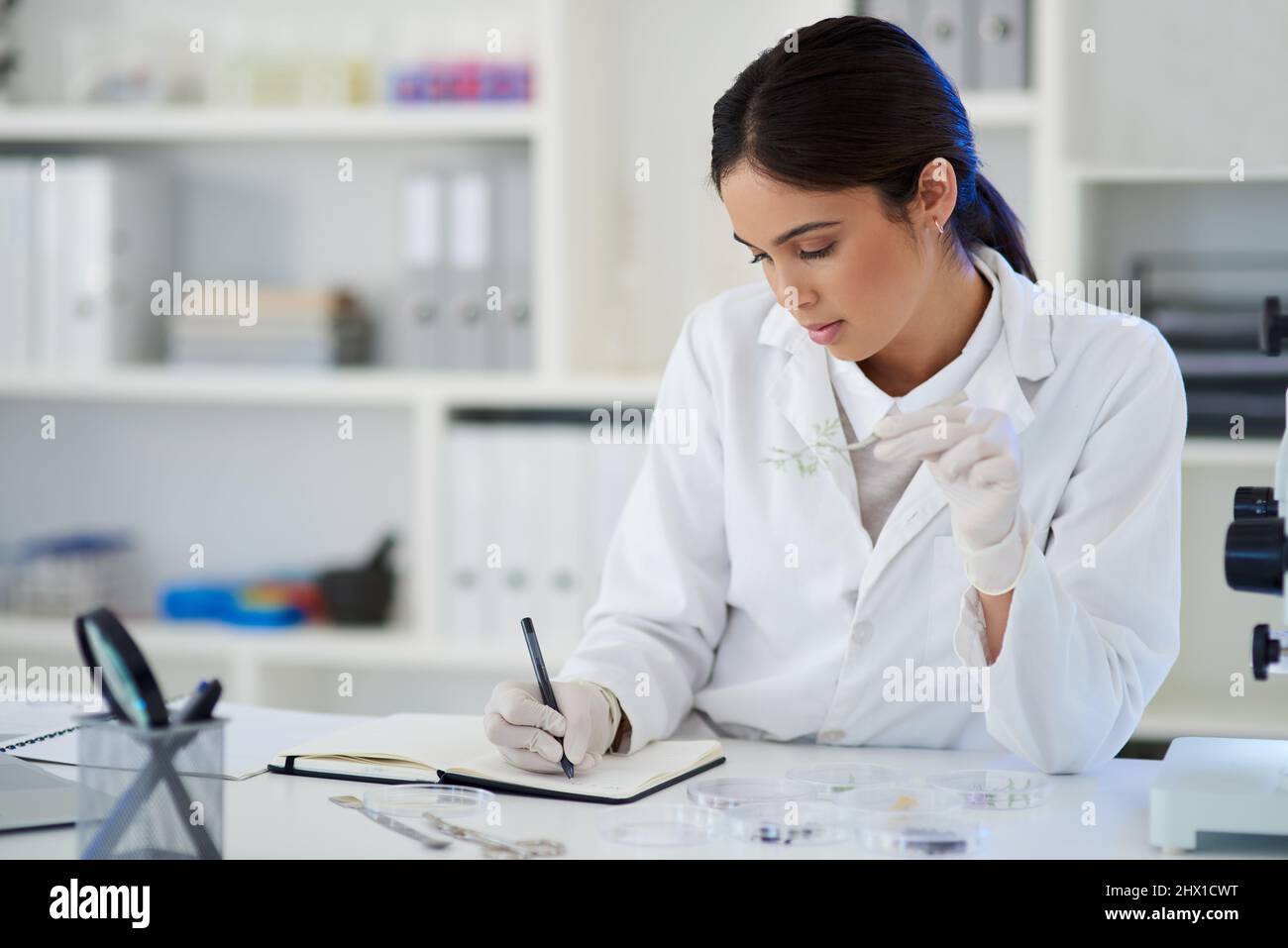 Thats something worth noting. Shot of a young scientist writing notes ...