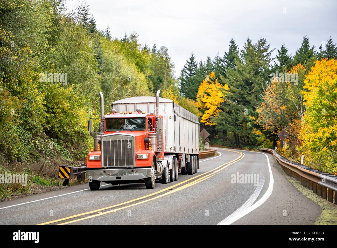 Big rig orange industrial classic semi truck with day cab transporting ...