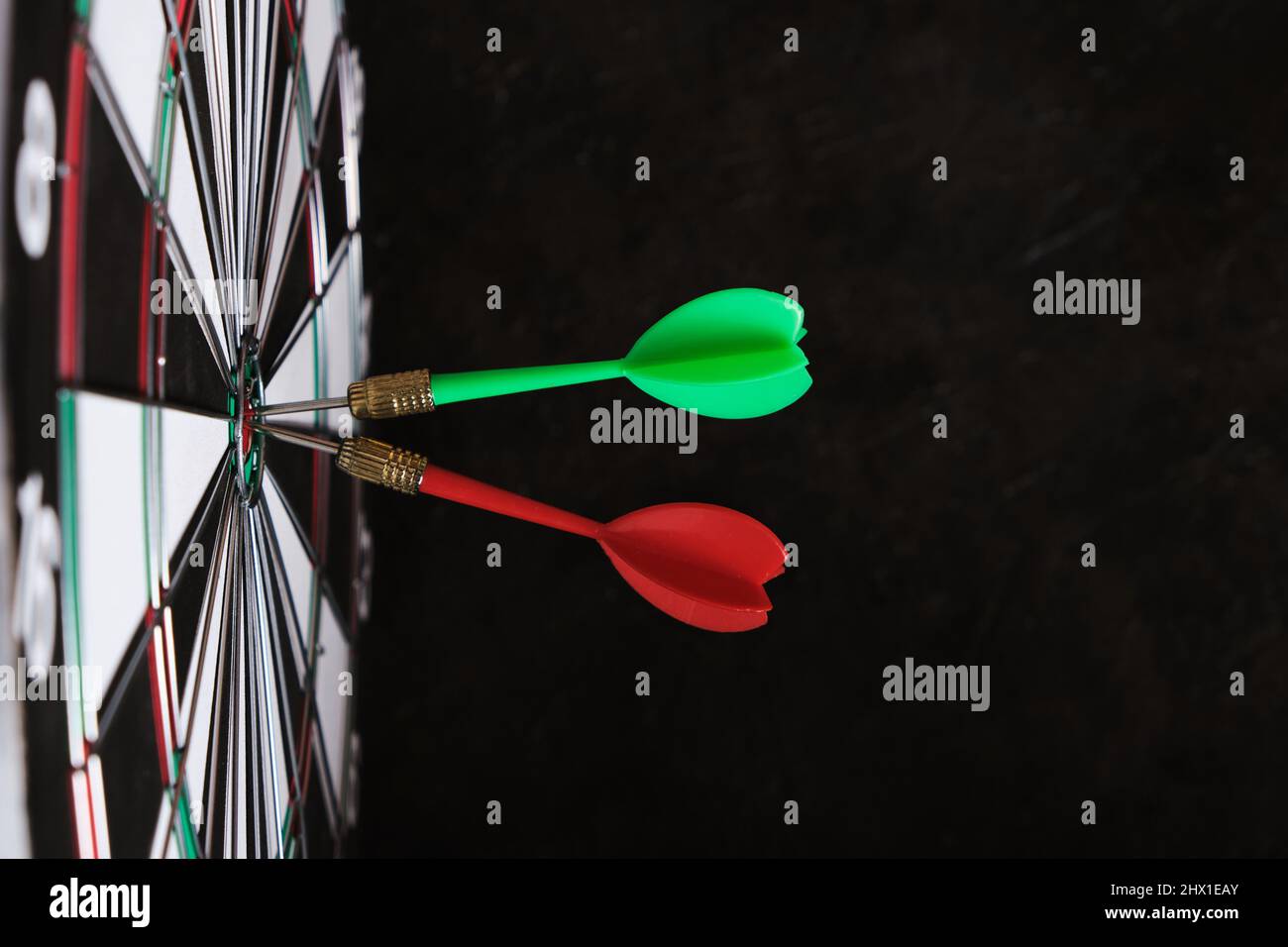 Two darts are stuck in the center of dartboard.Achieving goals in ...