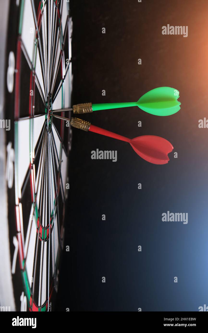 Two darts are stuck in the center of dartboard.Achieving goals in ...