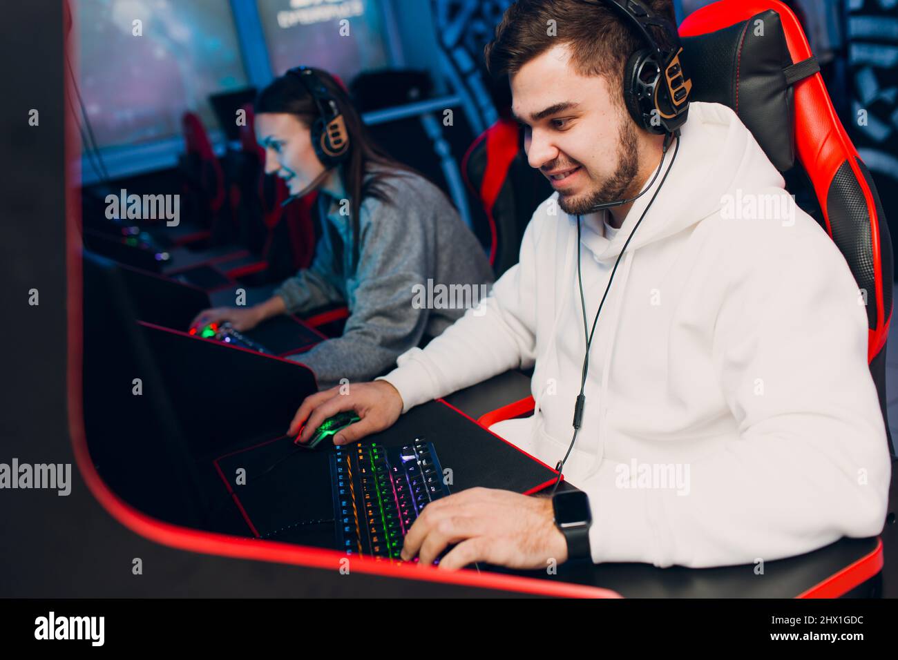 Guy and girl gamers playing gaming game on computer at club. Concept ...