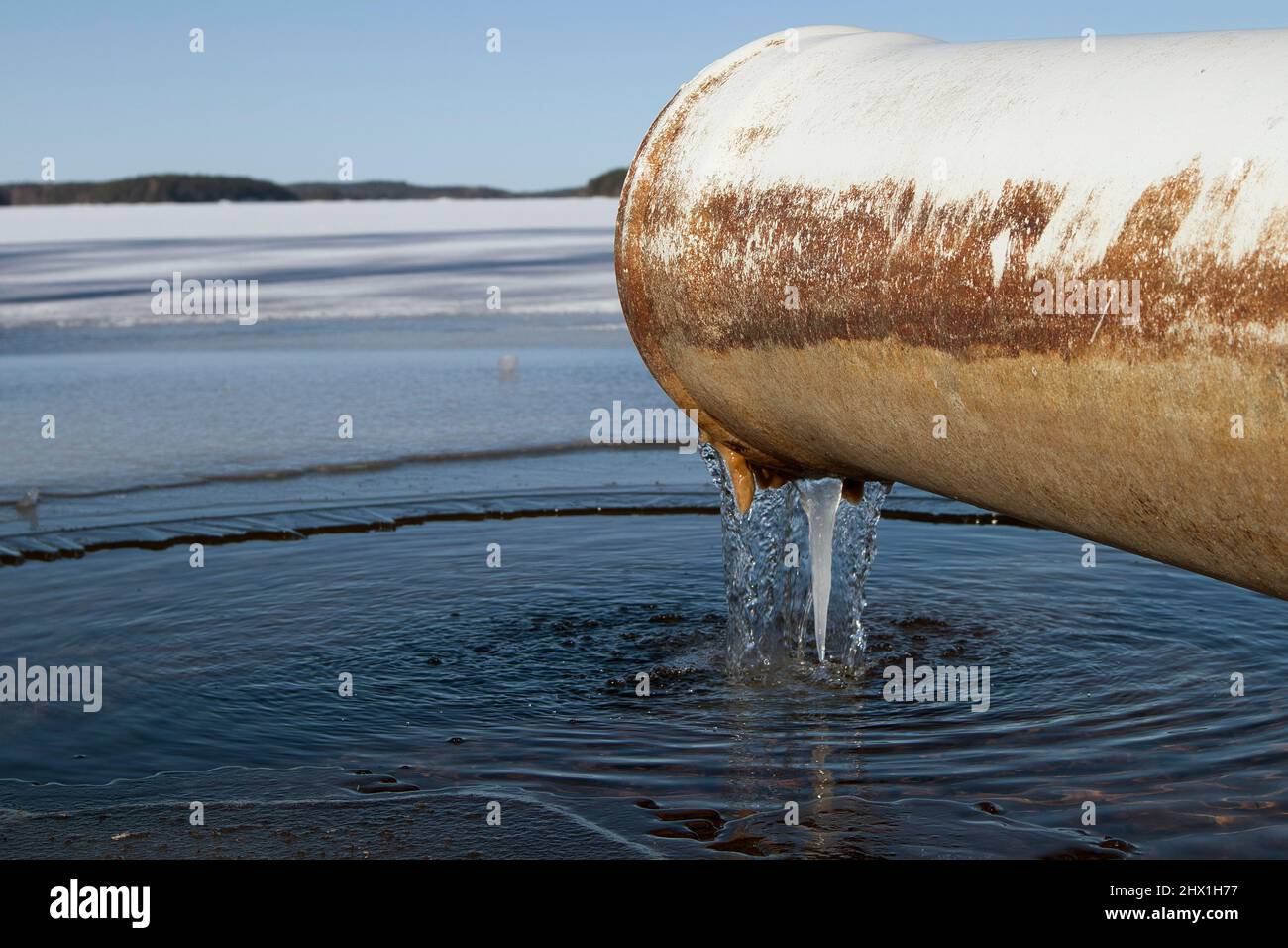 water running out of drain pipe into frozen lake, Finland Stock Photo ...