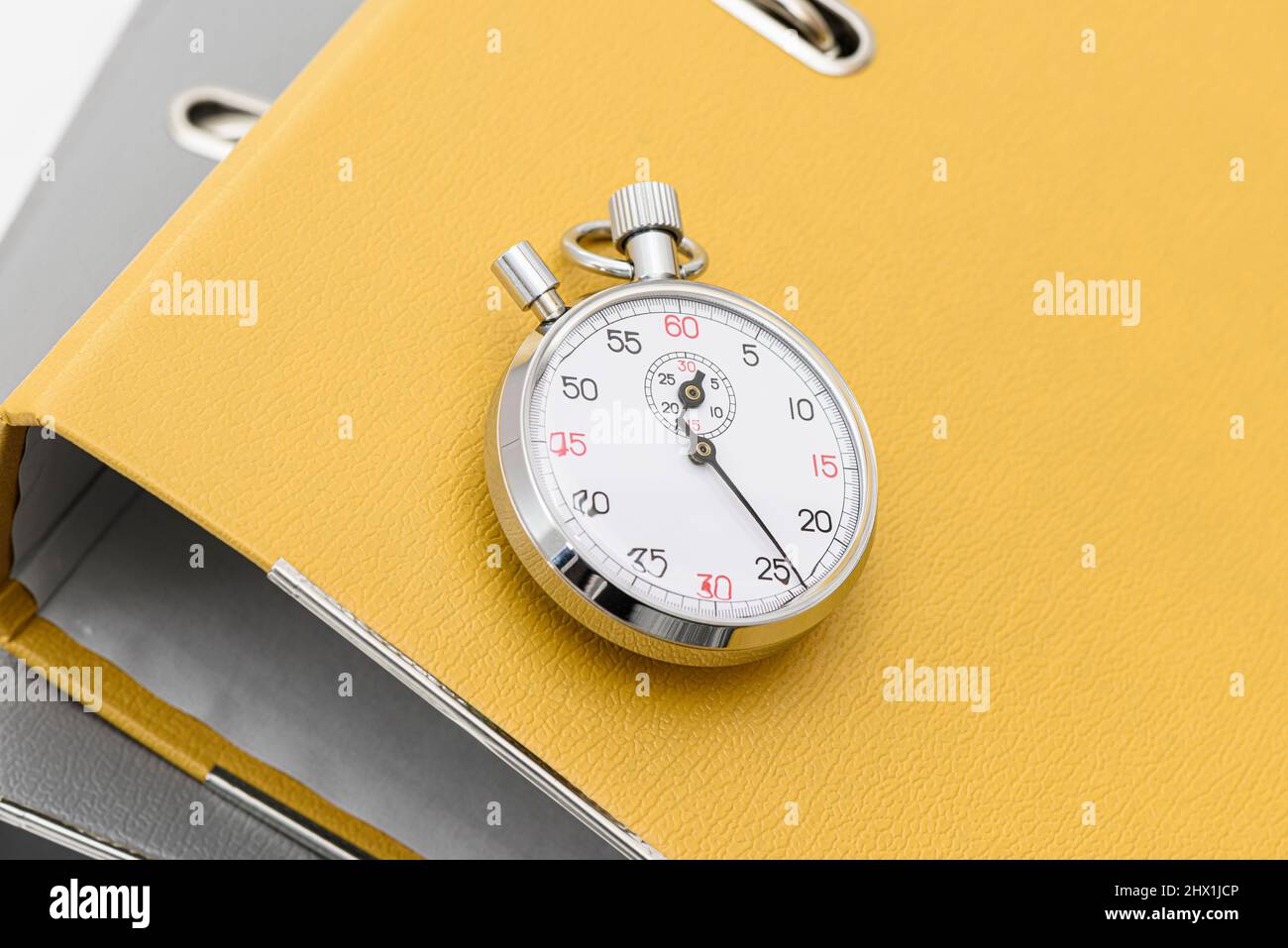 Yellow office folder on the chronometer Stock Photo - Alamy