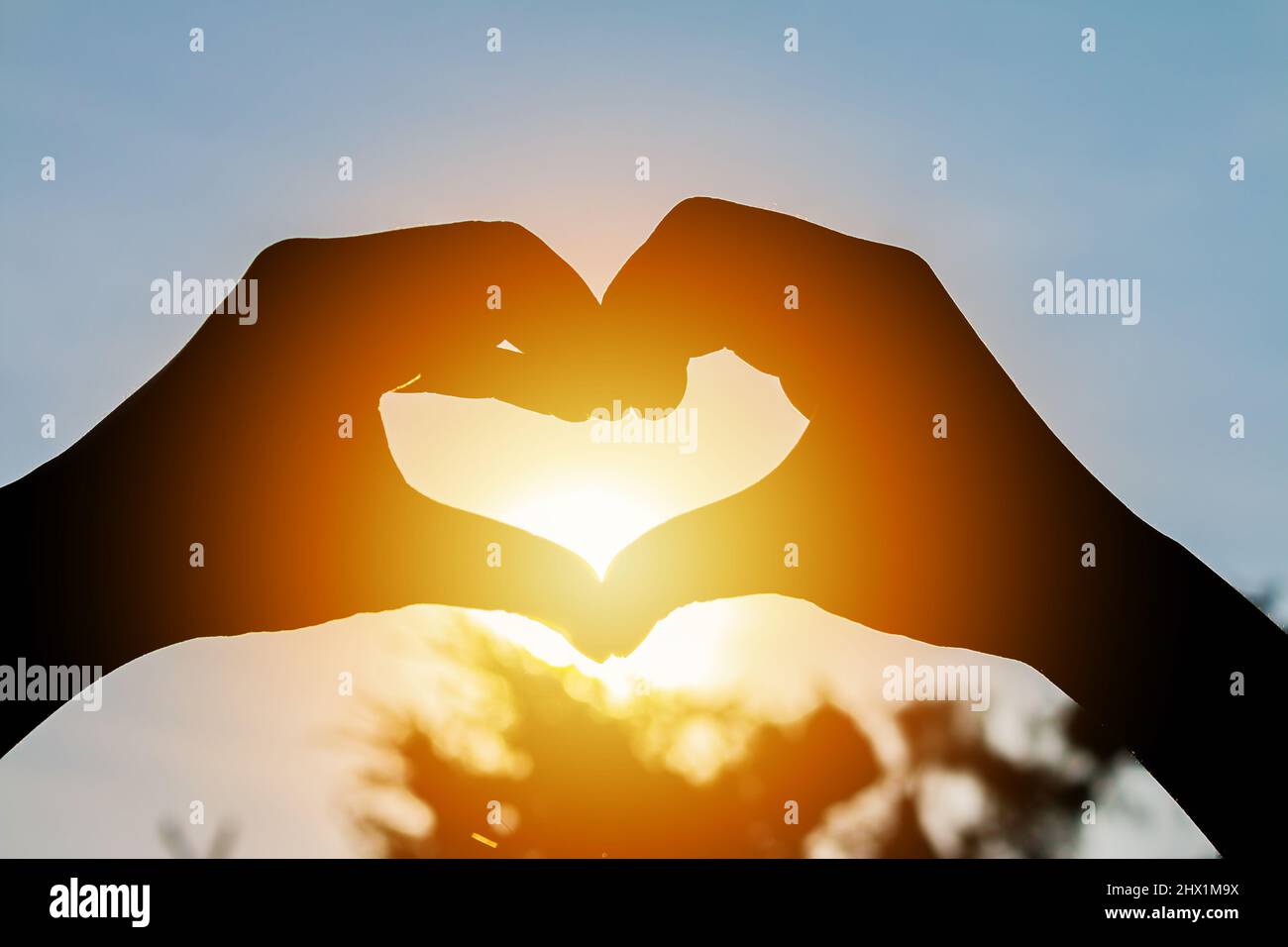 love shape hand silhouette at sunset background Stock Photo - Alamy