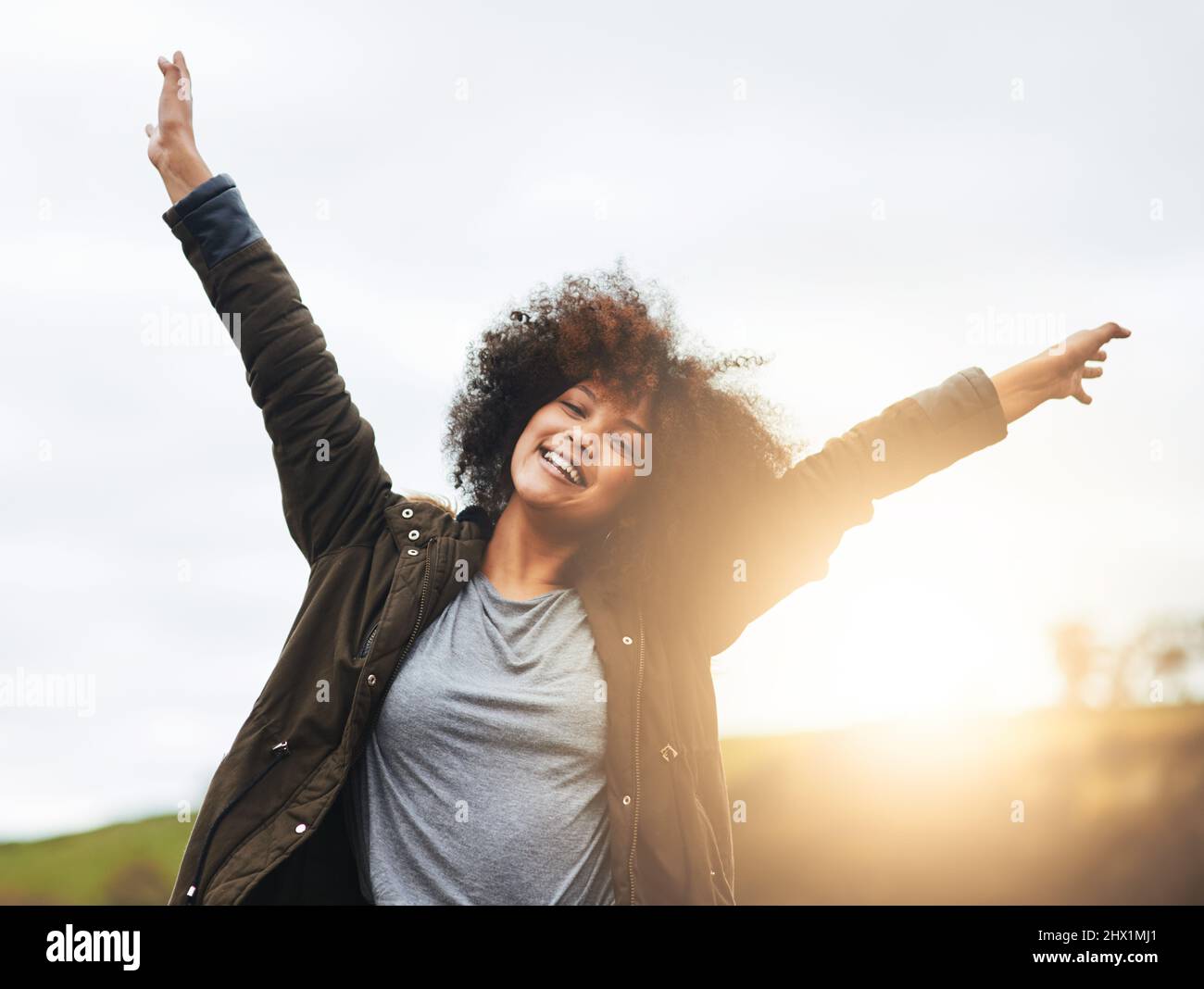 Life is for celebrating. Portrait of a joyful young woman raising her ...