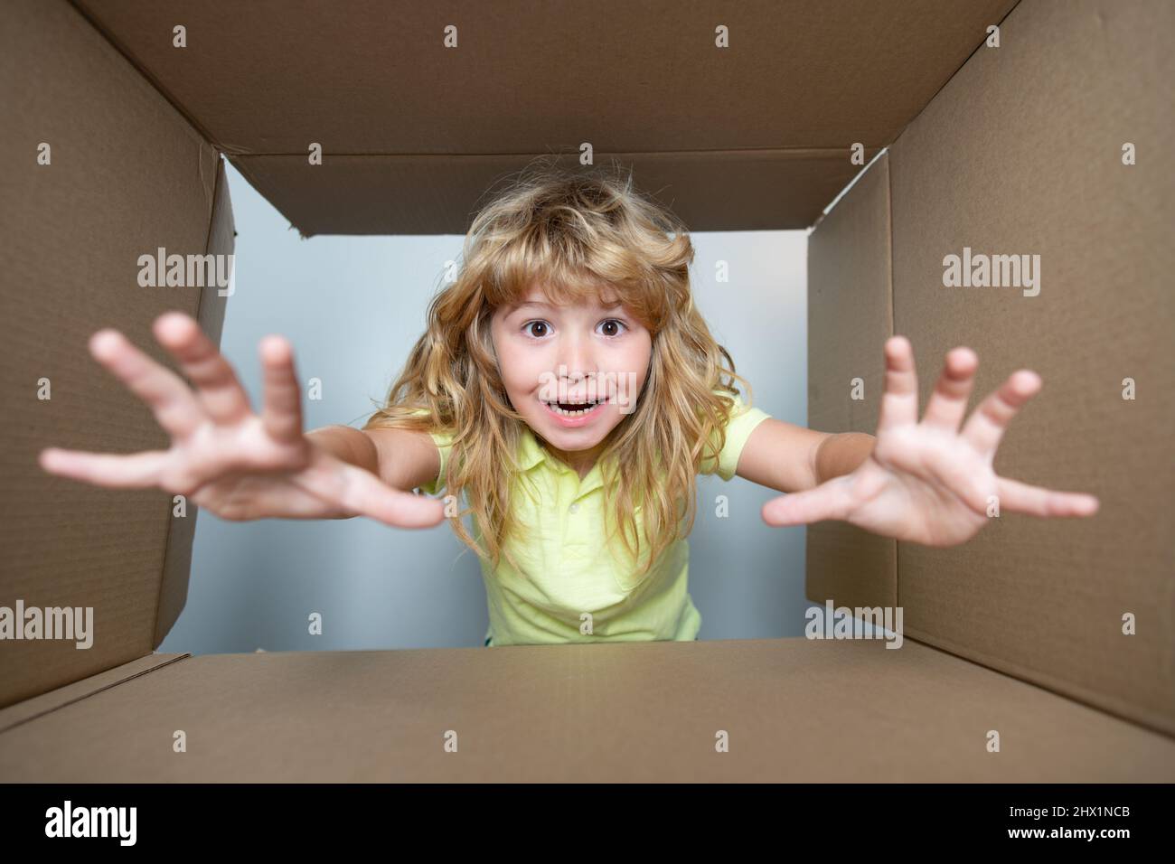 Happy child with cardboard box, unpacking parcel from internet store ...