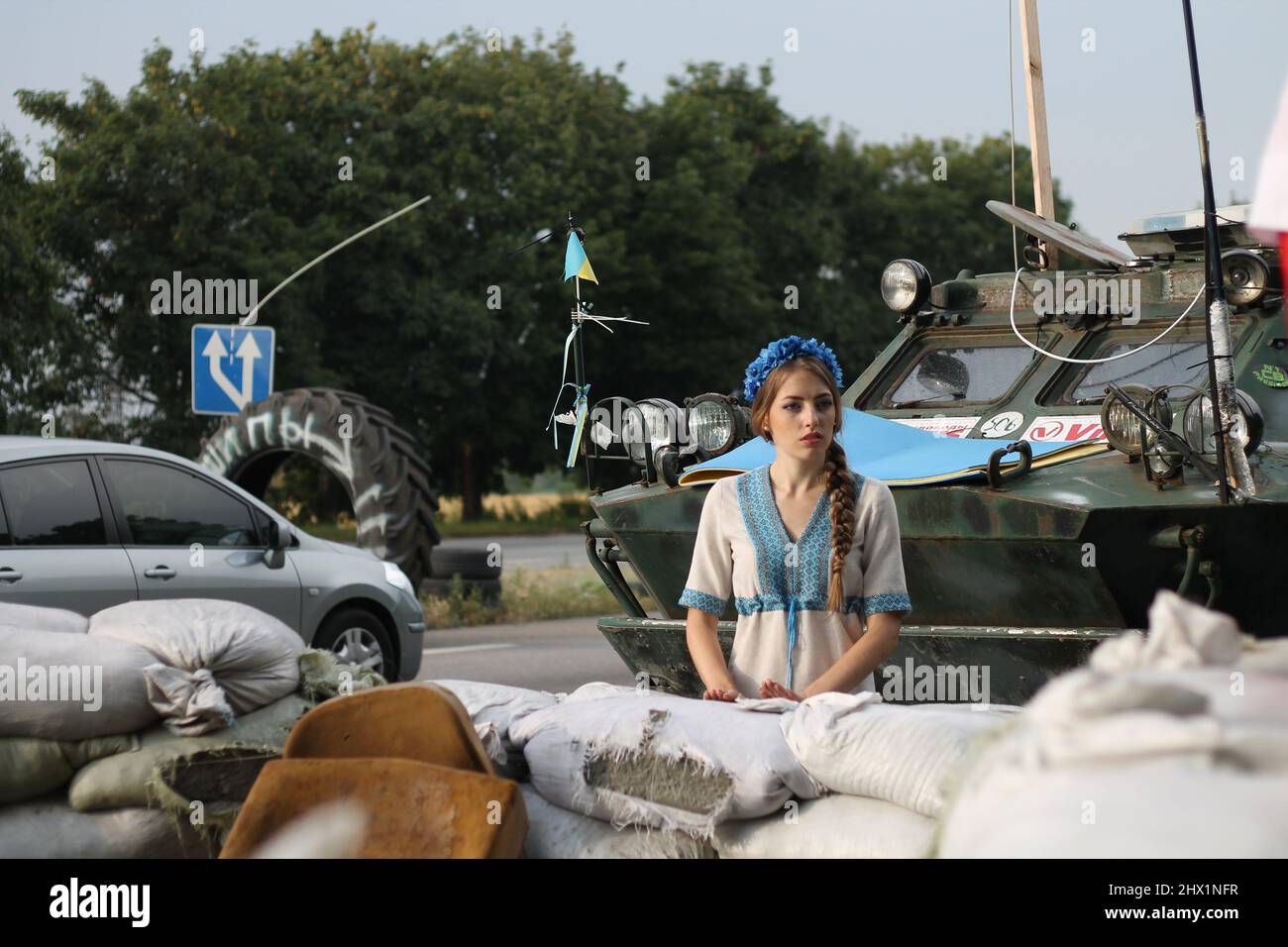 Young ukrainian woman in traditional national dress stands on roadblock ...