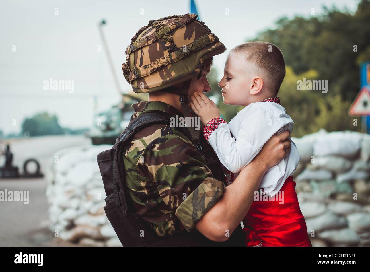 Ukrainian soldier holds child boy in traditional national dress in his ...